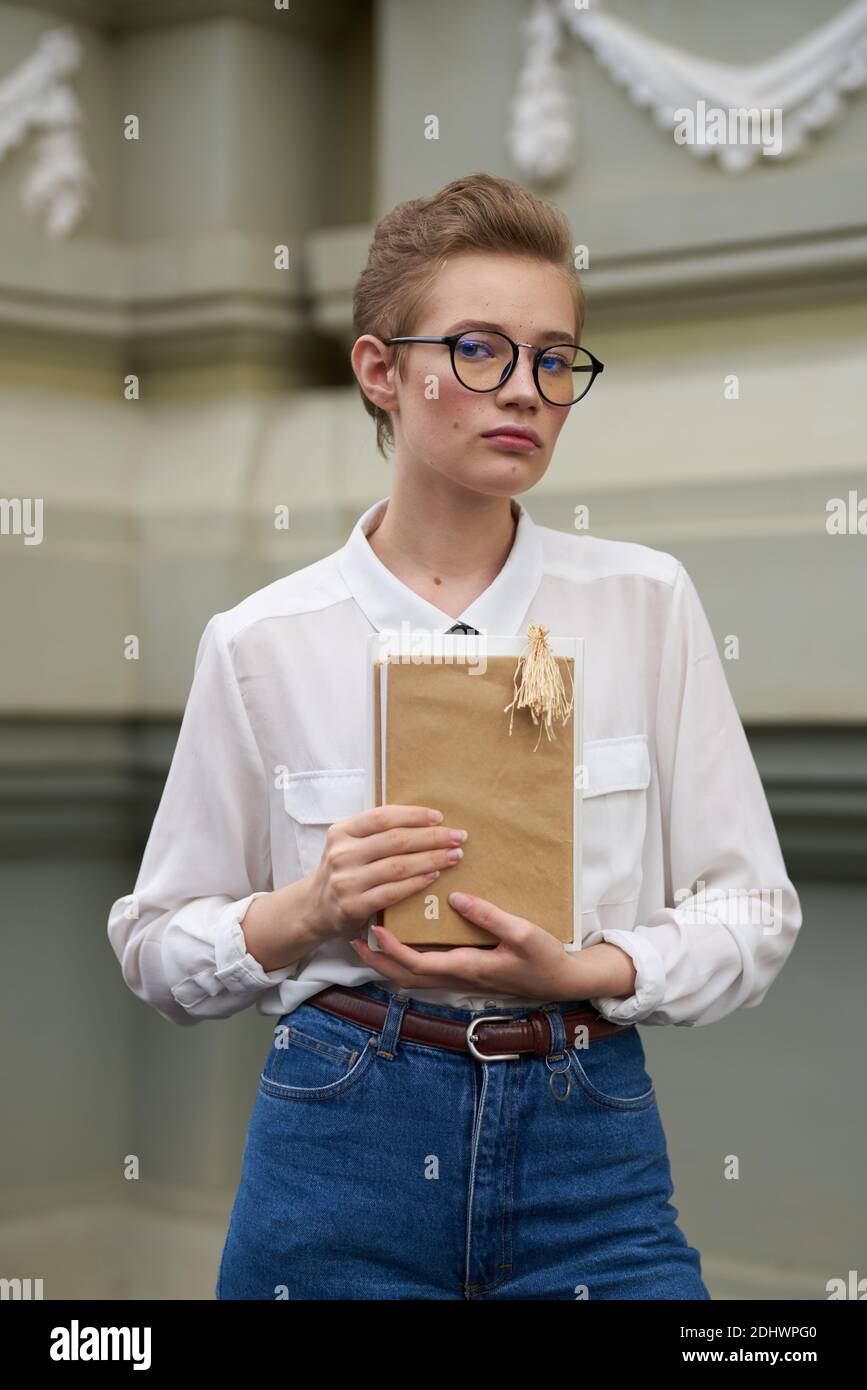 beautiful woman student with book in hand near building suit model ...
