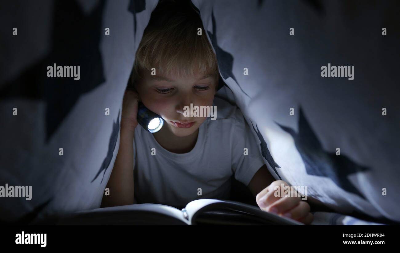 Child read under covers hi-res stock photography and images - Alamy