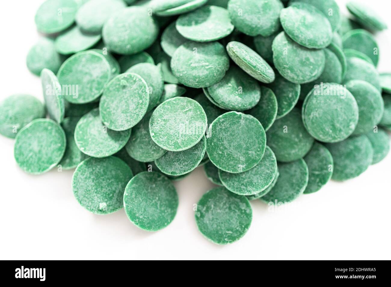 Green round chocolate chips for melting chocolate shapes on a white ...