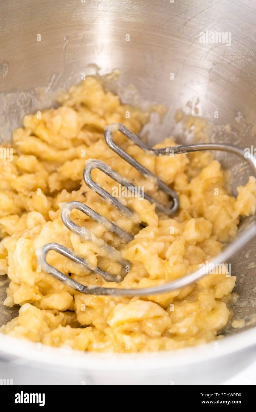Peeling and smashing overripe bananas to make banana nut bread Stock ...