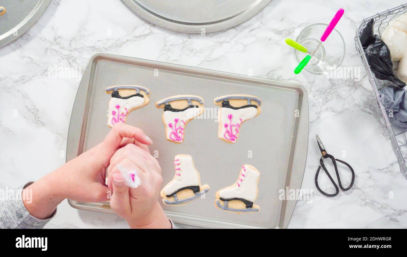 Flat lay. Icing figure skate shaped sugar cookies with royal icing ...