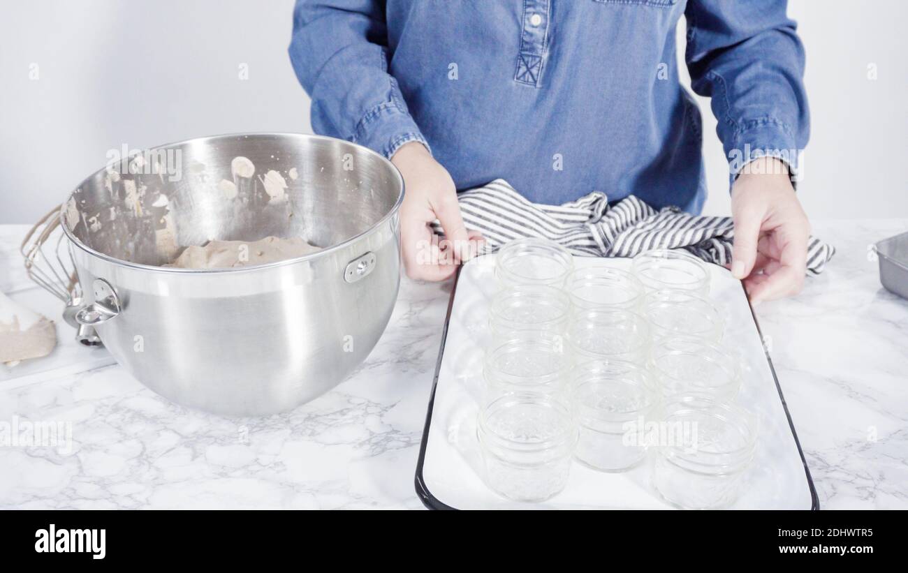 Step by step. Scooping homemade chocolate ice cream into glass jars ...