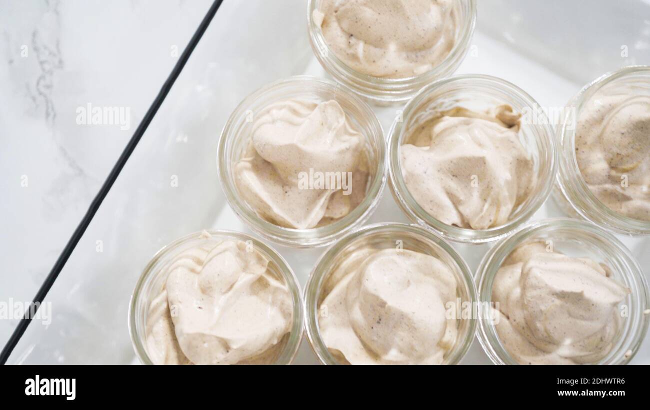 Step by step. Scooping homemade chocolate ice cream into glass jars ...