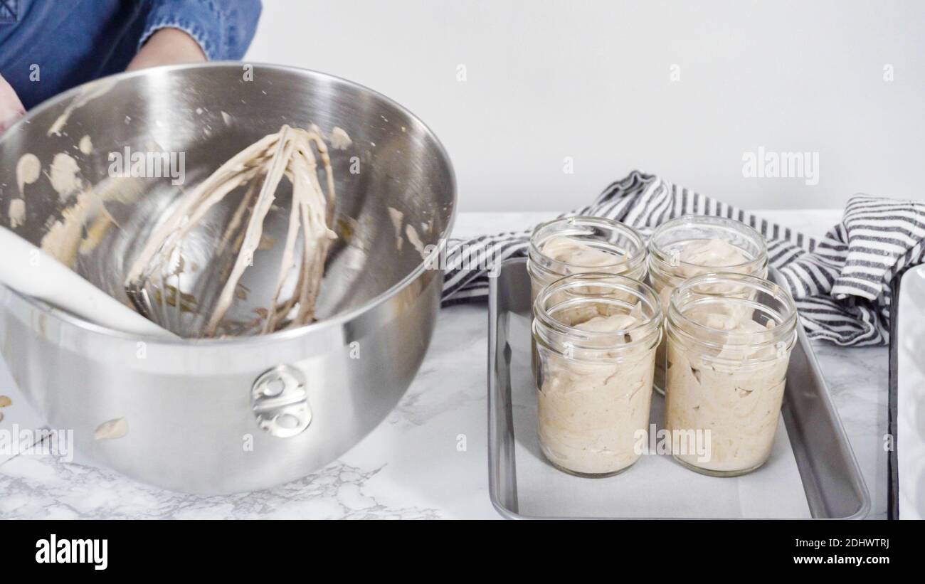 Step by step. Scooping homemade chocolate ice cream into glass jars ...