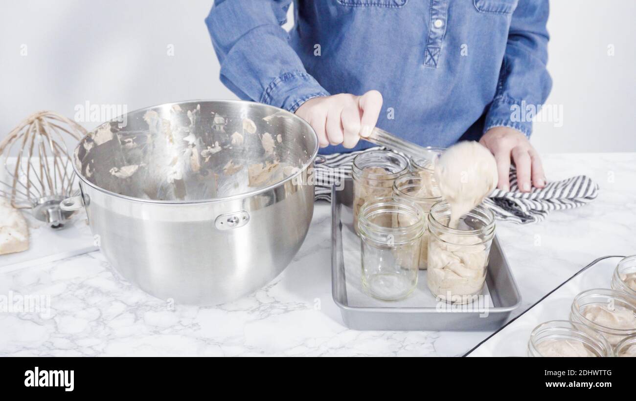 Step by step. Scooping homemade chocolate ice cream into glass jars ...