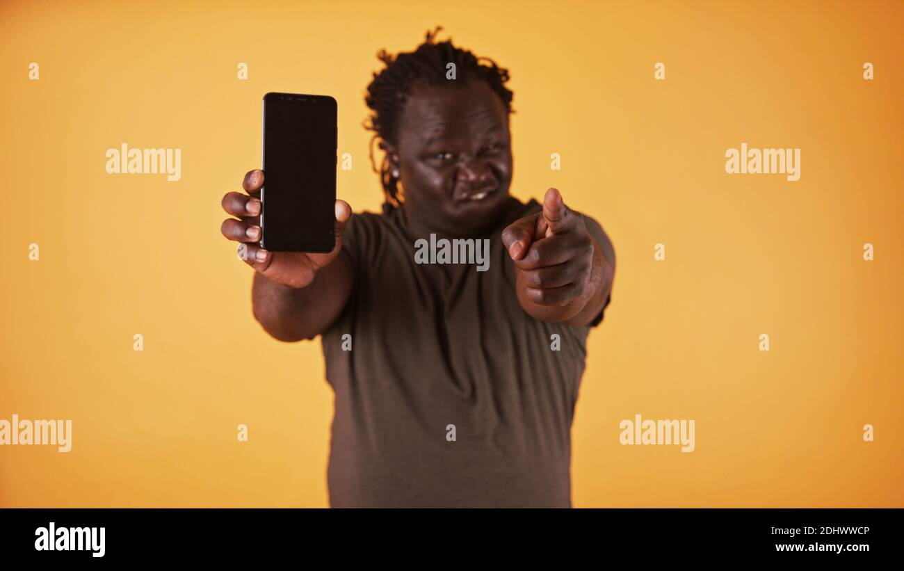 Angry african american black man showing phone screen and pointing ...