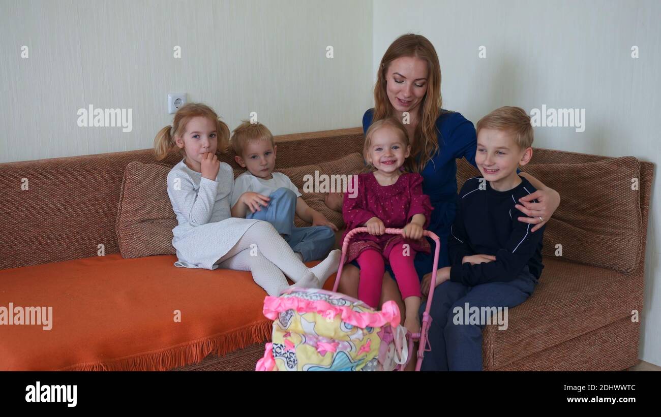 Happy mother of many children with her children on the couch in the ...