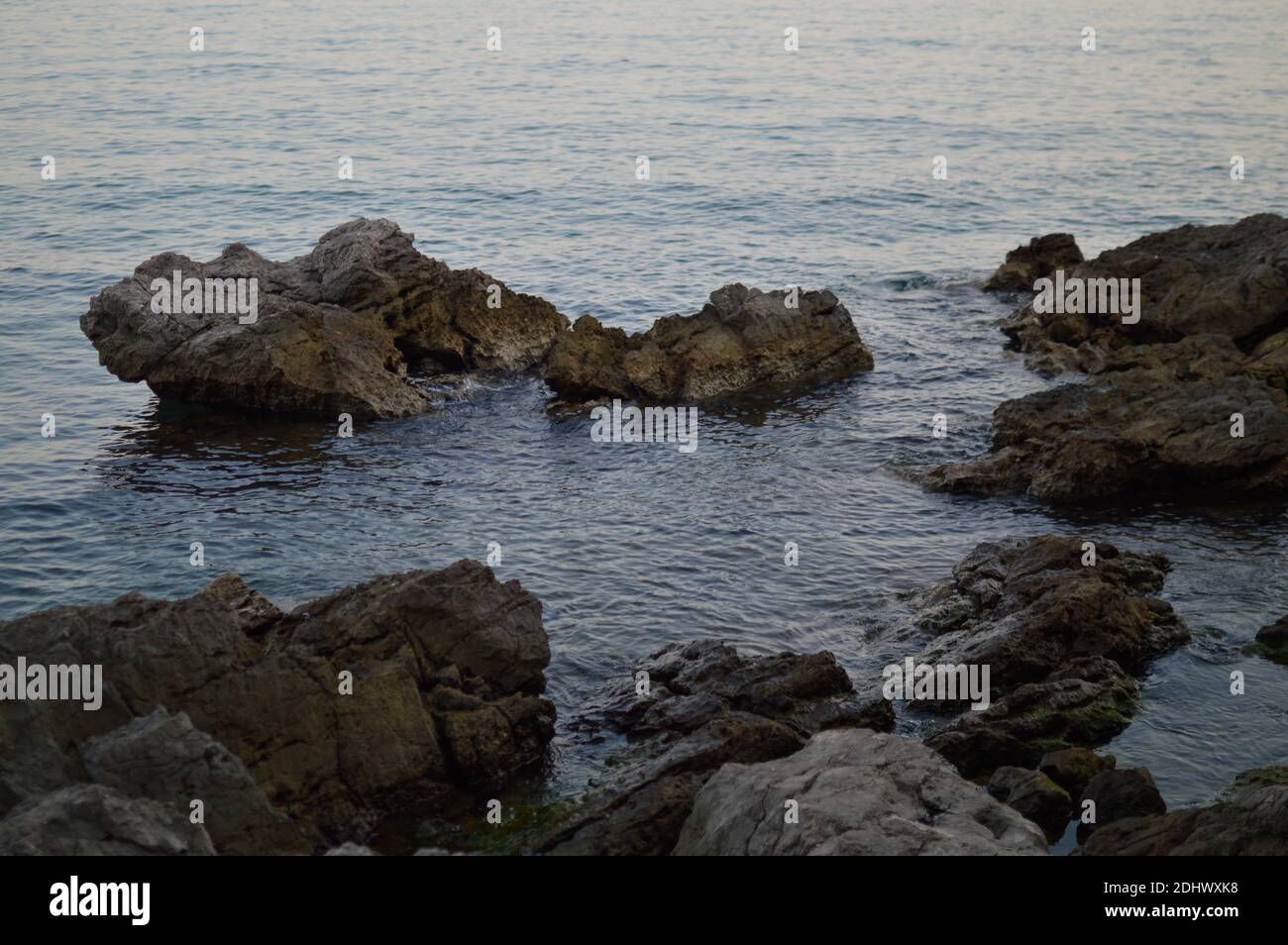 Rocks at the beach, calm water, small waves, clear water Stock Photo ...