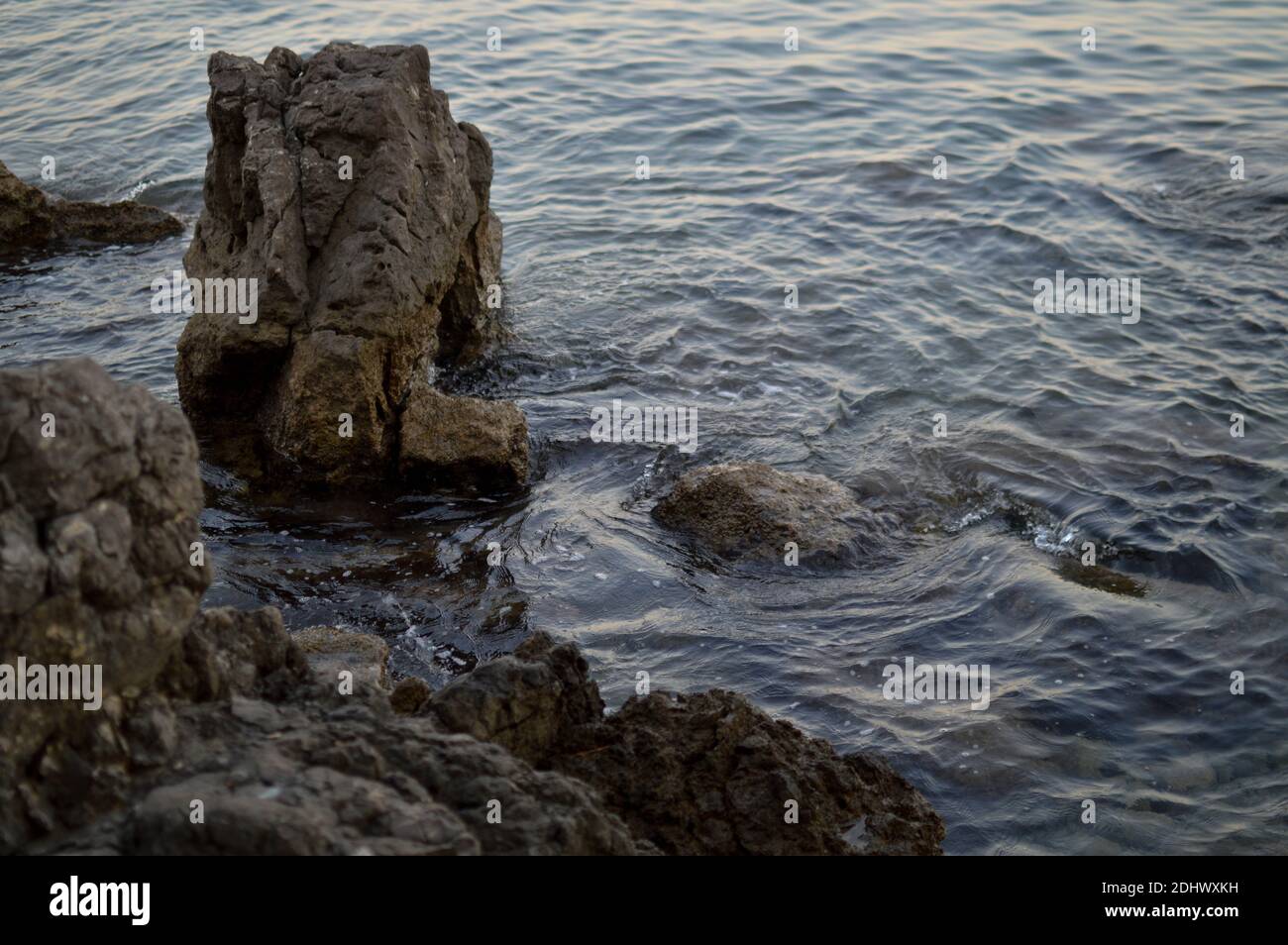 Rocks at the beach, calm water, small waves, clear water Stock Photo ...