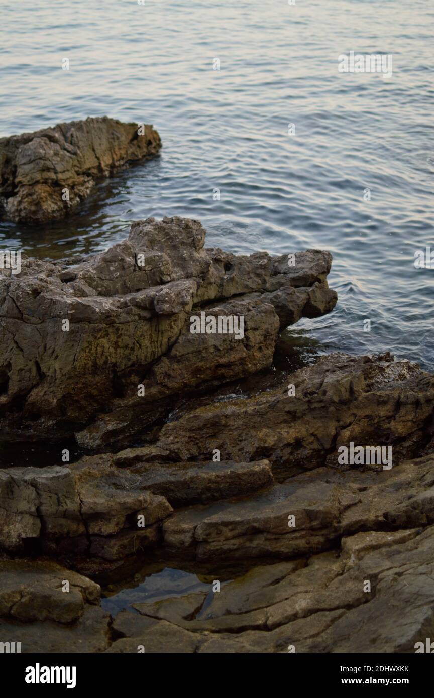 Rocks at the beach, calm water, small waves, clear water Stock Photo ...