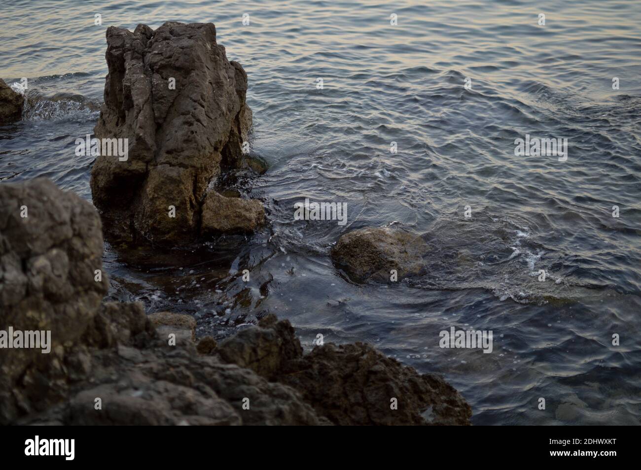 Rocks at the beach, calm water, small waves, clear water Stock Photo ...