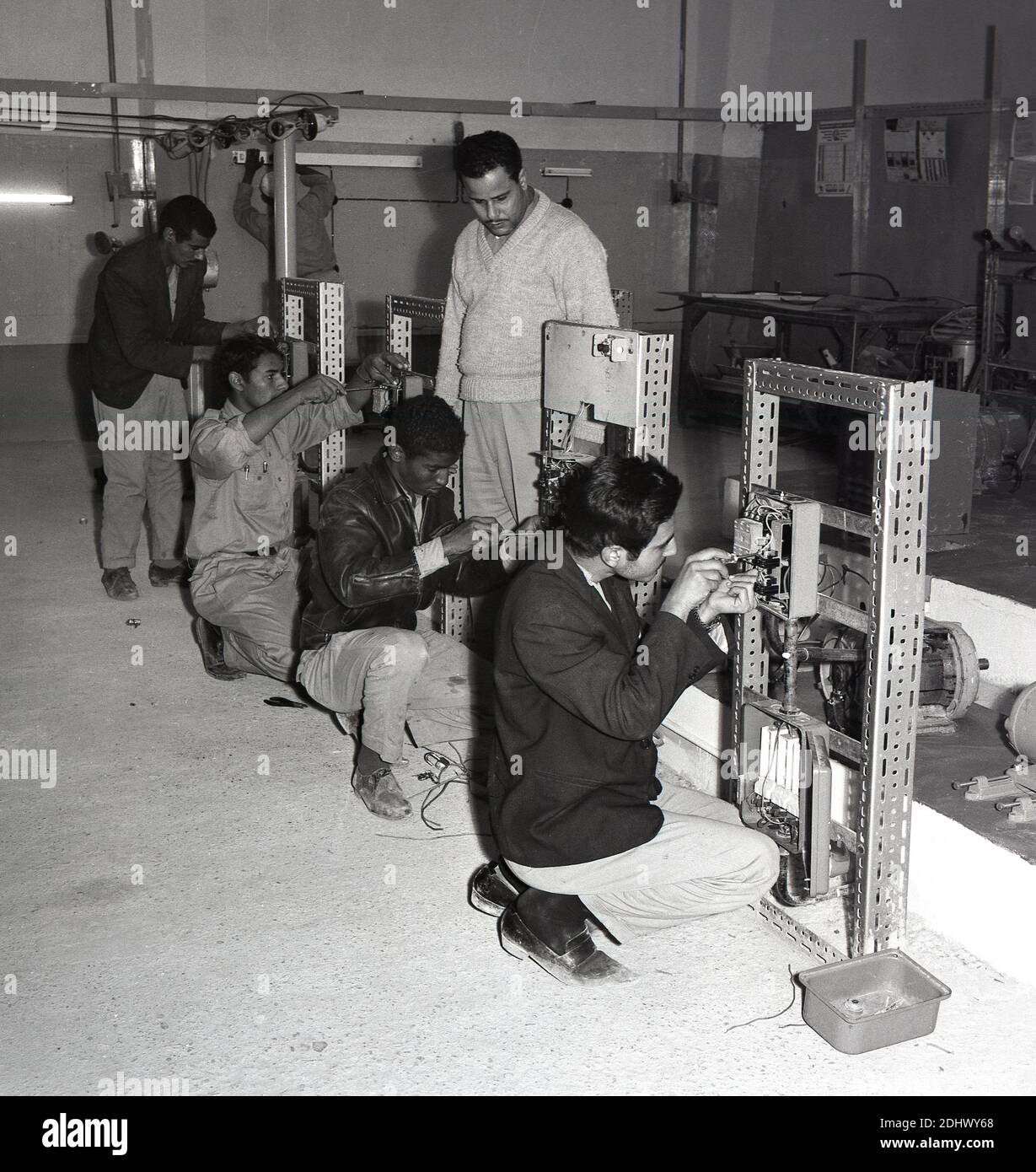 1960s, historical, arab male tutor overlooking the work of a four male ...