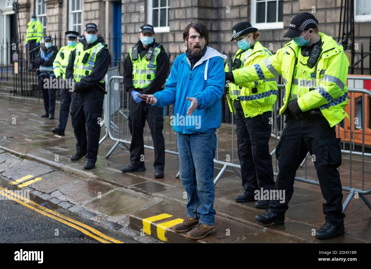 Police push back an anti-lockdown protester away from the steps of Bute ...