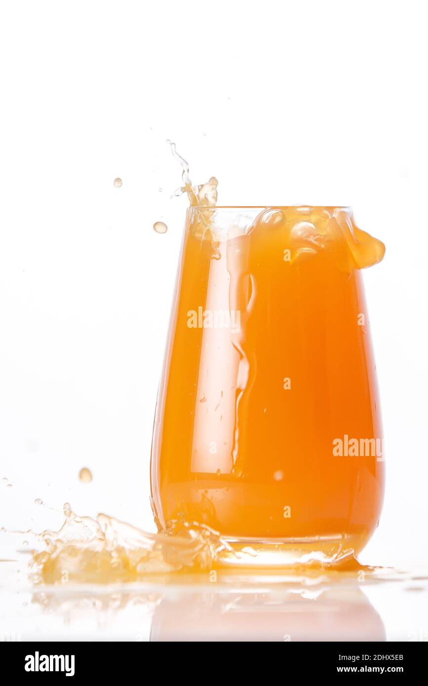 The glass of splashing fruit juice isolated on white background Stock ...