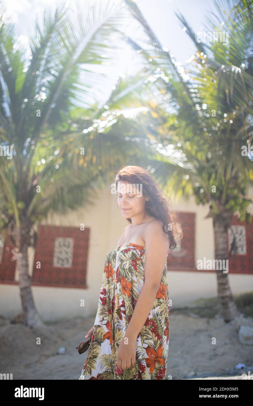Beautiful woman wearing a dress standing in a tropical street Stock ...