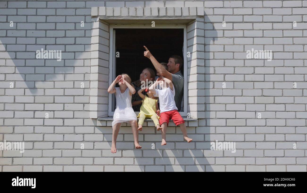 A friendly family appears in the window of their house Stock Photo - Alamy