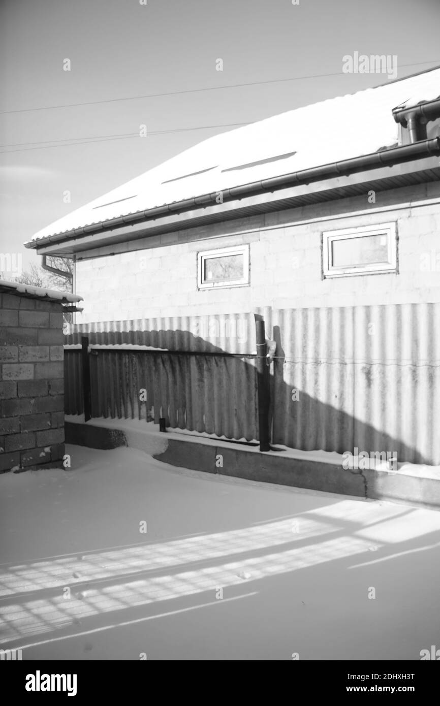 Winter rural courtyard in the snow in winter. Slate old fence and ...