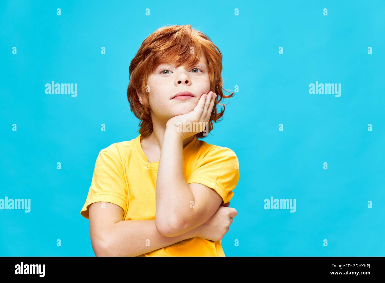 Portrait of red-haired boy holding hand on face emotions lifestyle ...
