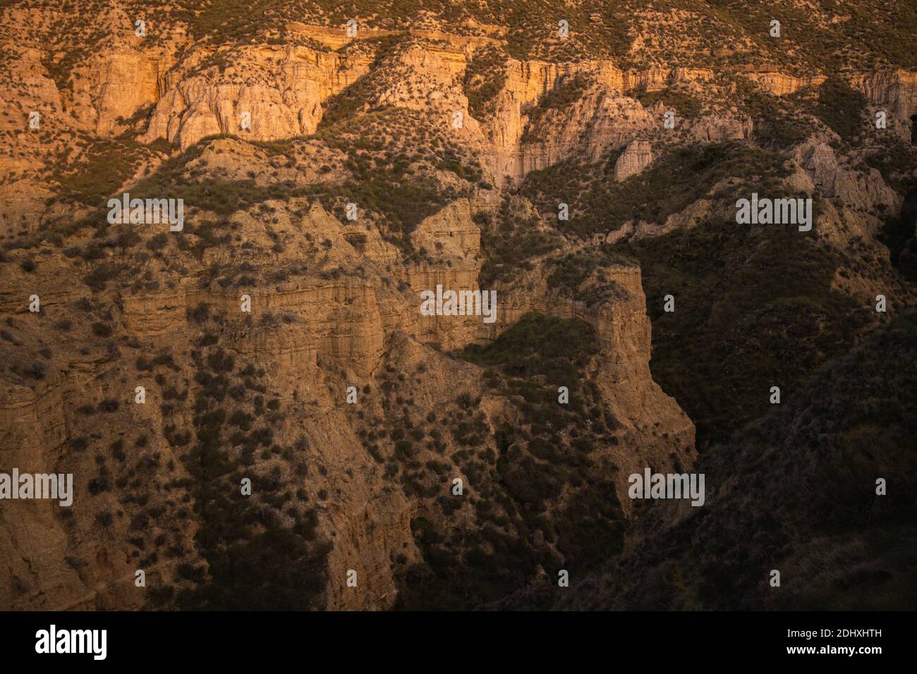 closed shot of badlands with reflected sunlight and small bushes Stock ...