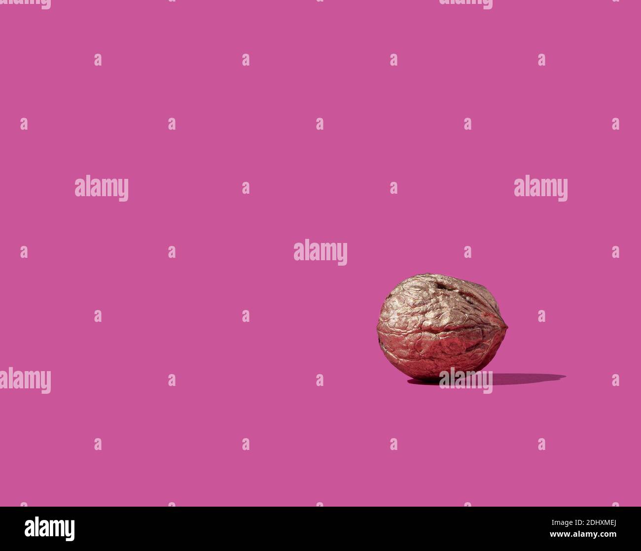 Gold walnut on bright pink background Stock Photo - Alamy