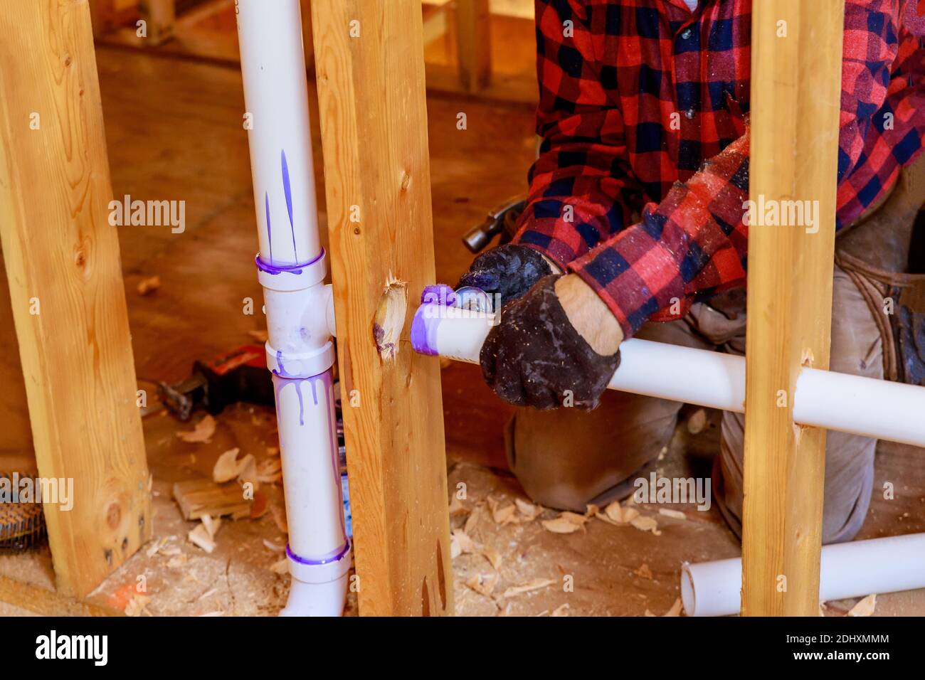 Plumbing contractor installing PVC plastic drain pipe in the section ...