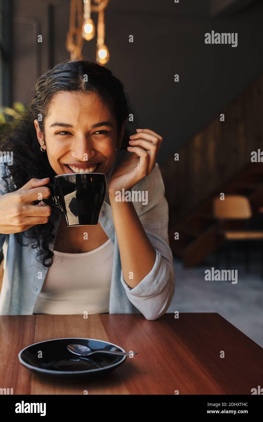 Beautiful woman having a hot cup of coffee in a cafe. Smiling female ...
