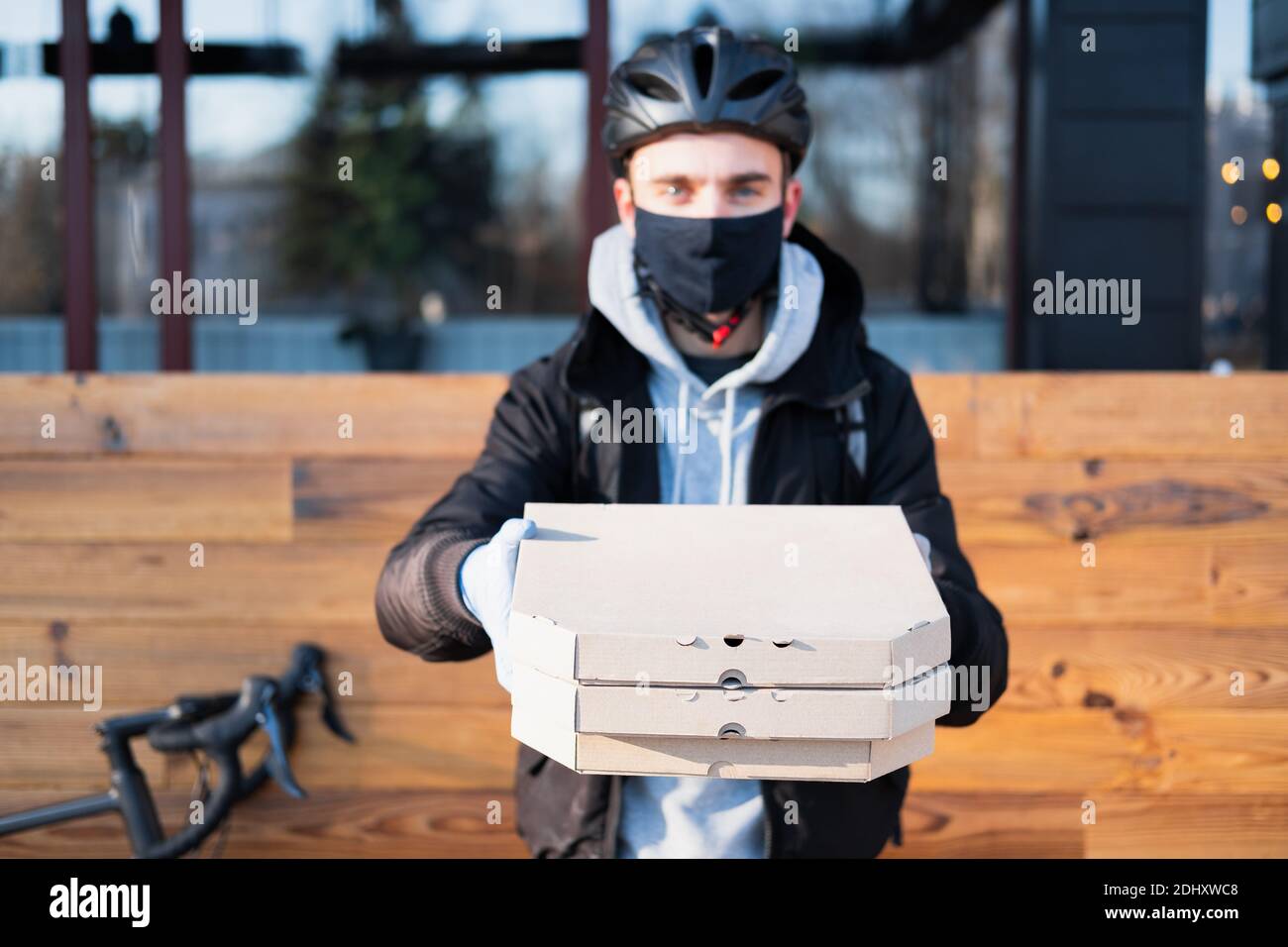Delivery person holds pizza boxes in a stretched out hand, focus on ...