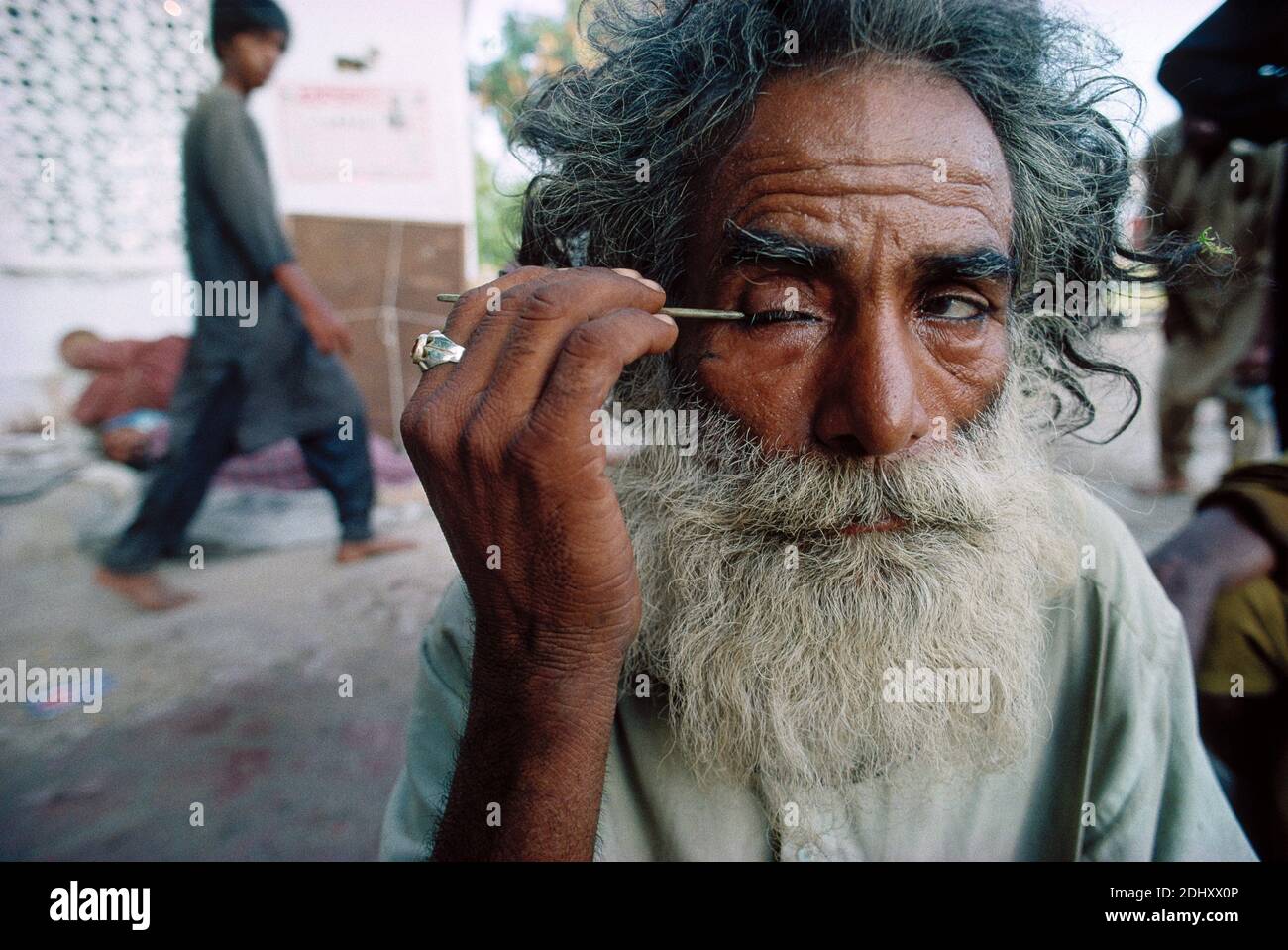 portrait of a manl applying black kohl eyeliner around his eyes .Sindh ...