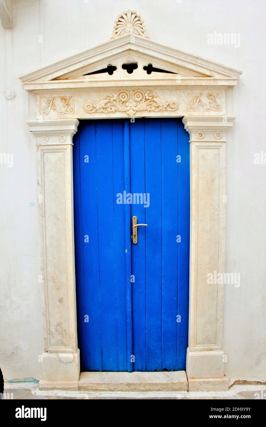 View of a house decorated with blue door and windows and marble lintel ...