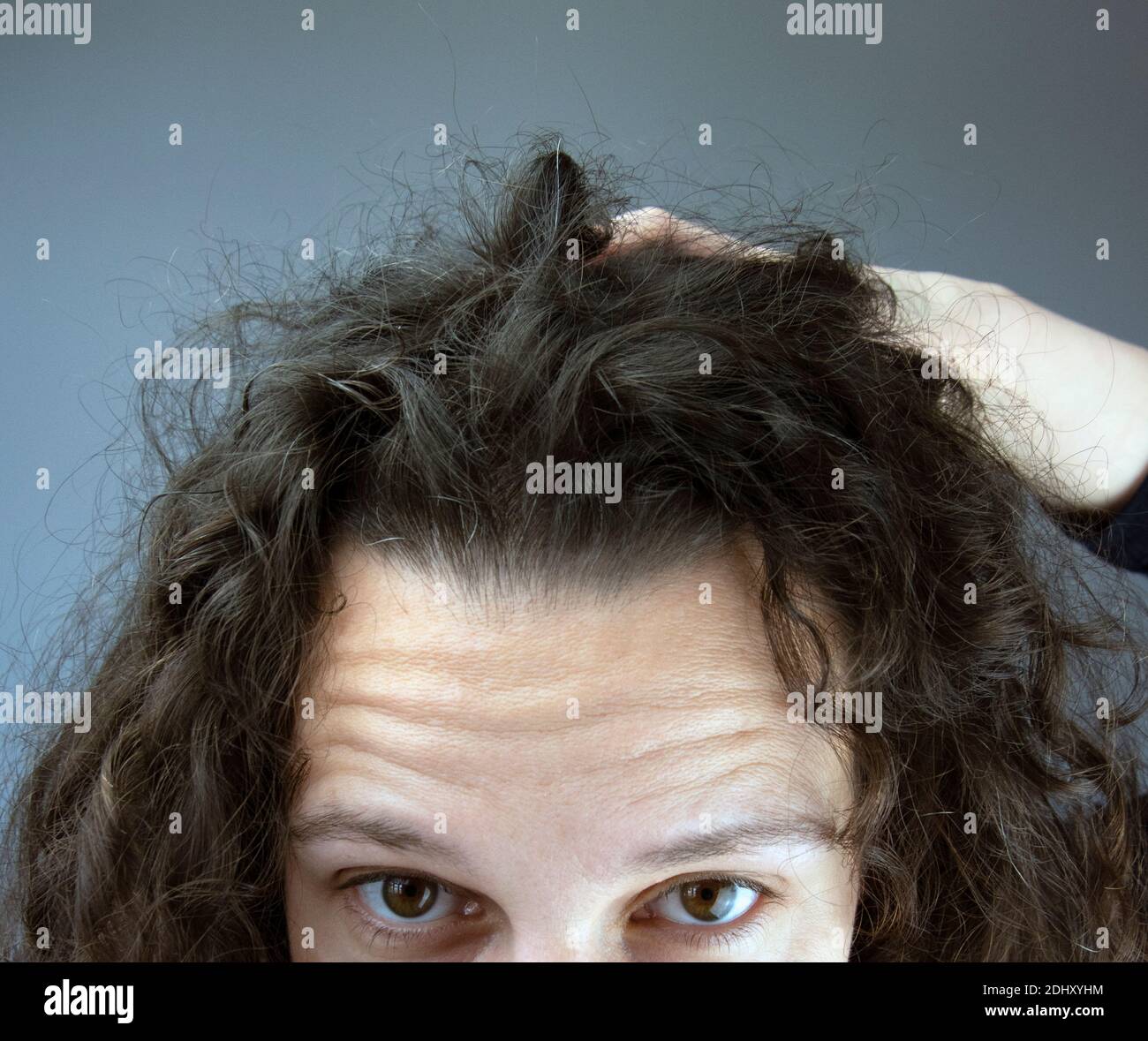 Woman in her 30s checking hair for white hairs Stock Photo - Alamy