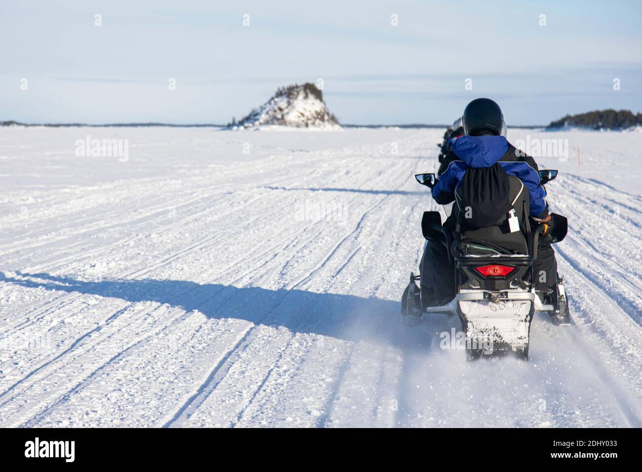 Snowmobile touristic tour on the frozen lake of Inari, in Lapland ...