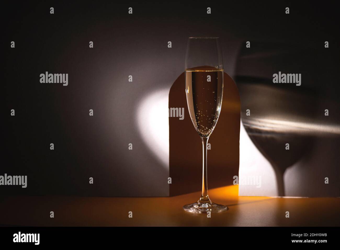 Stylish glass of champagne in hard light with creative shadows Stock ...
