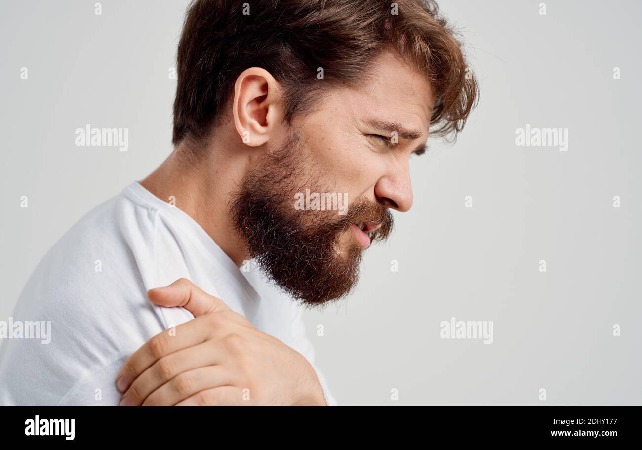 bearded man touching shoulder with hand pain dislocation medical ...