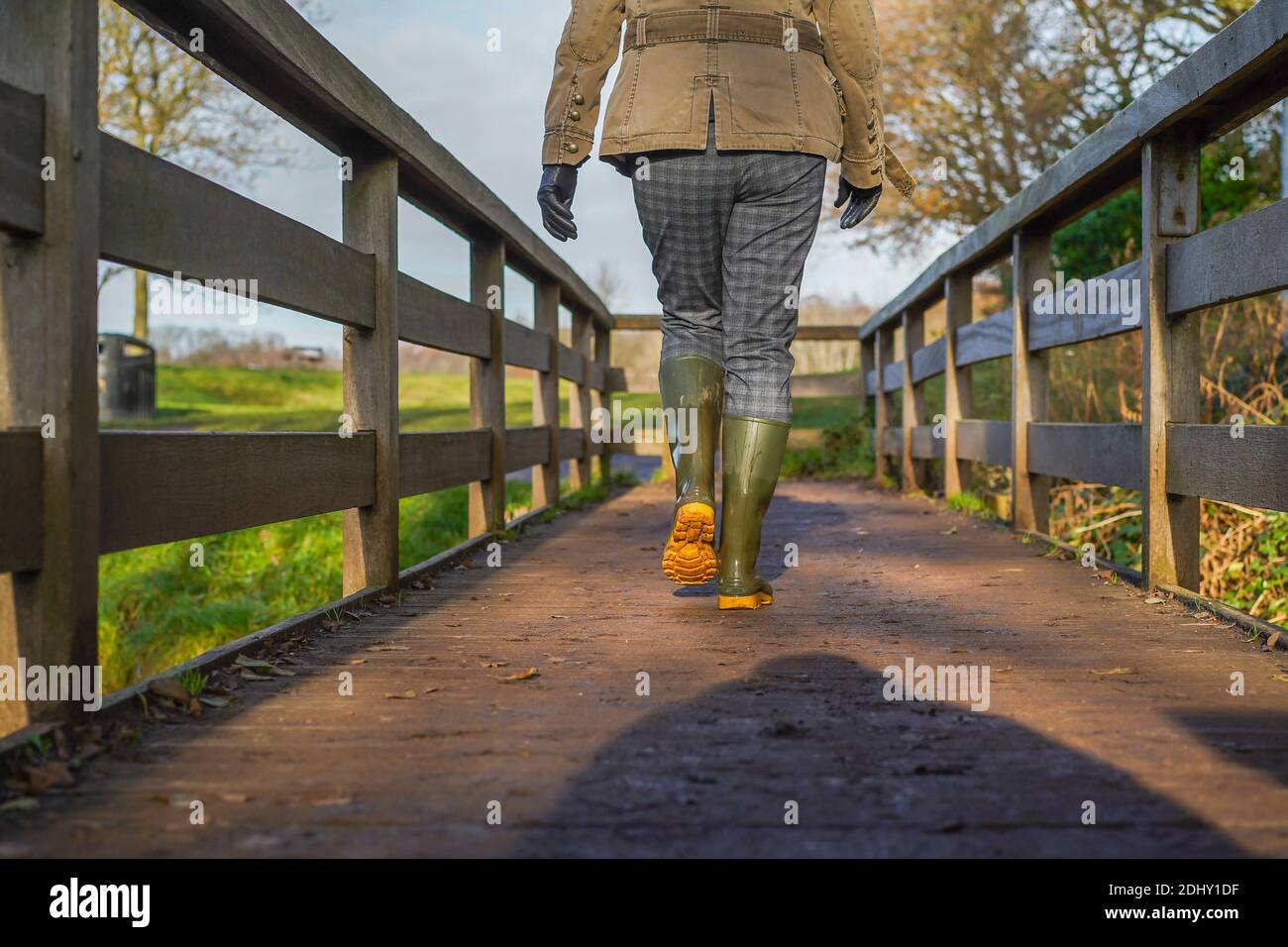 Low angle, rear view of UK woman in wellington boots/ wellies, isolated ...