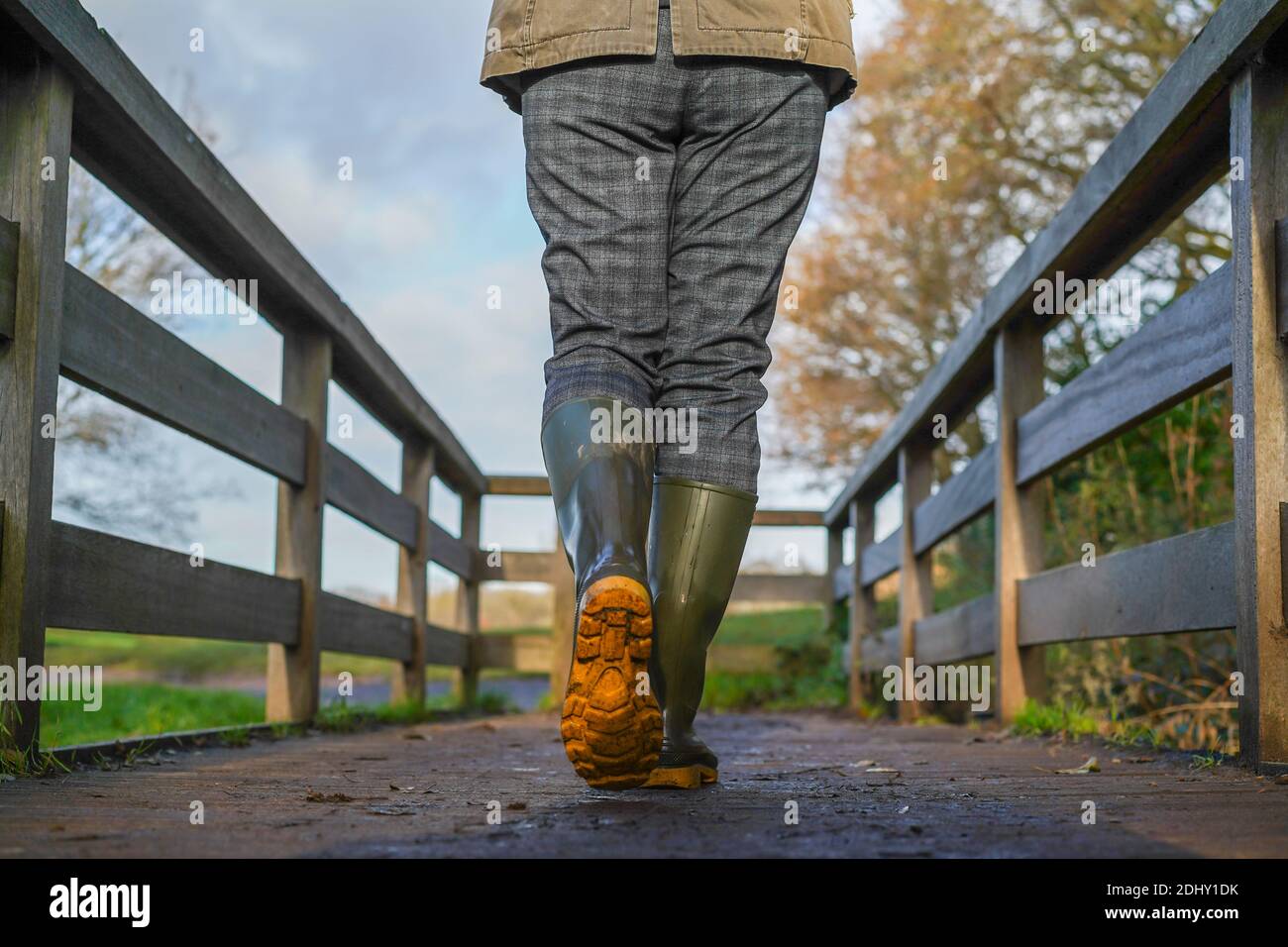 Low angle, rear view of UK woman in wellington boots/ wellies, isolated ...