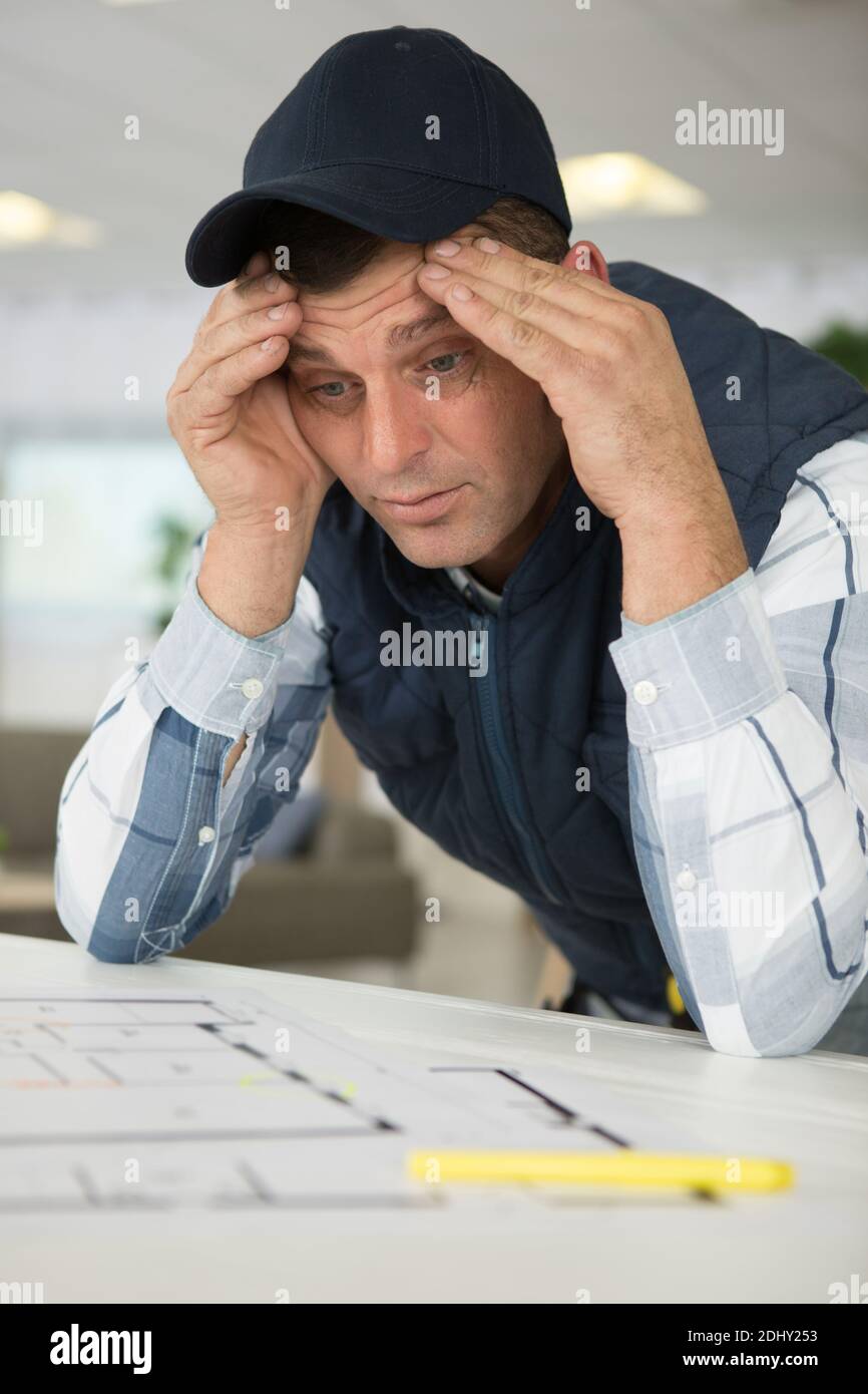 puzzled worker stressing over architectural plans Stock Photo - Alamy