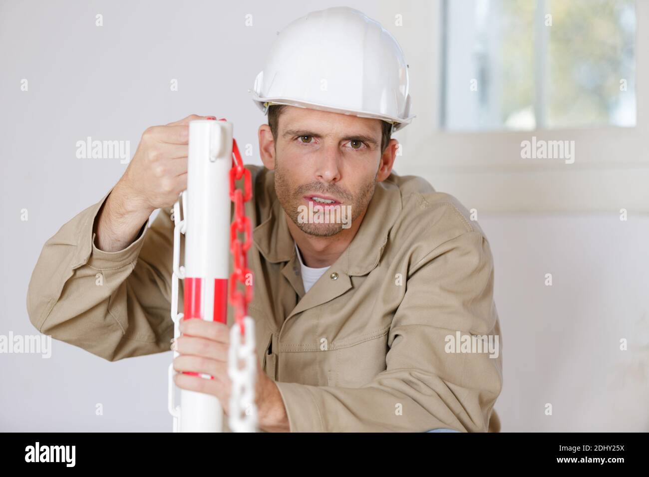 worker setting up safety exclusion barrier on site Stock Photo - Alamy