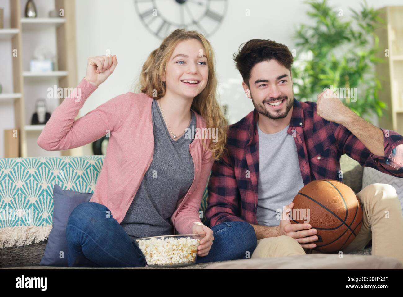 young couple watching basketball match on tv Stock Photo - Alamy