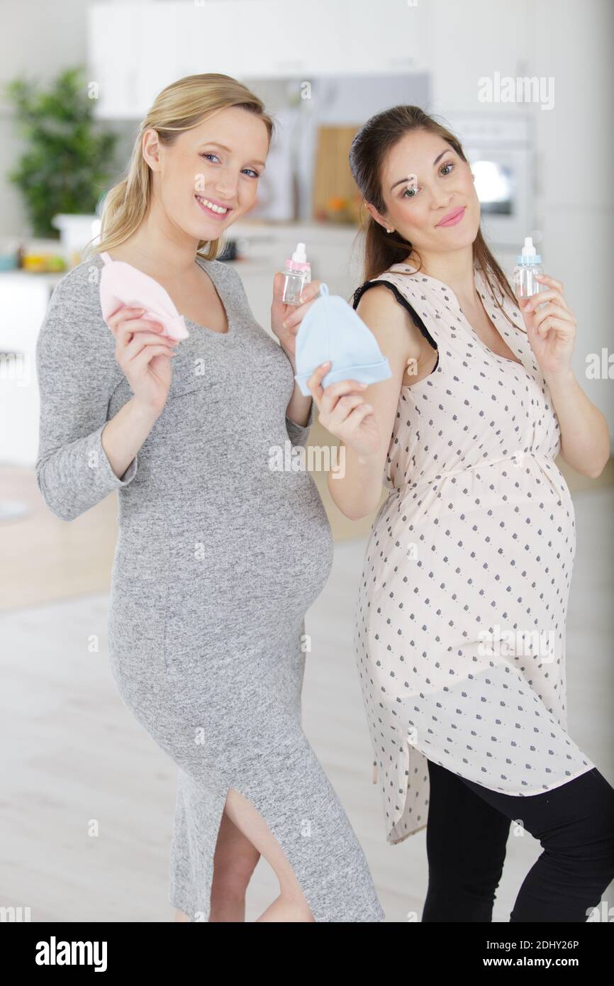 two pregnant women with newborn baby booties Stock Photo - Alamy