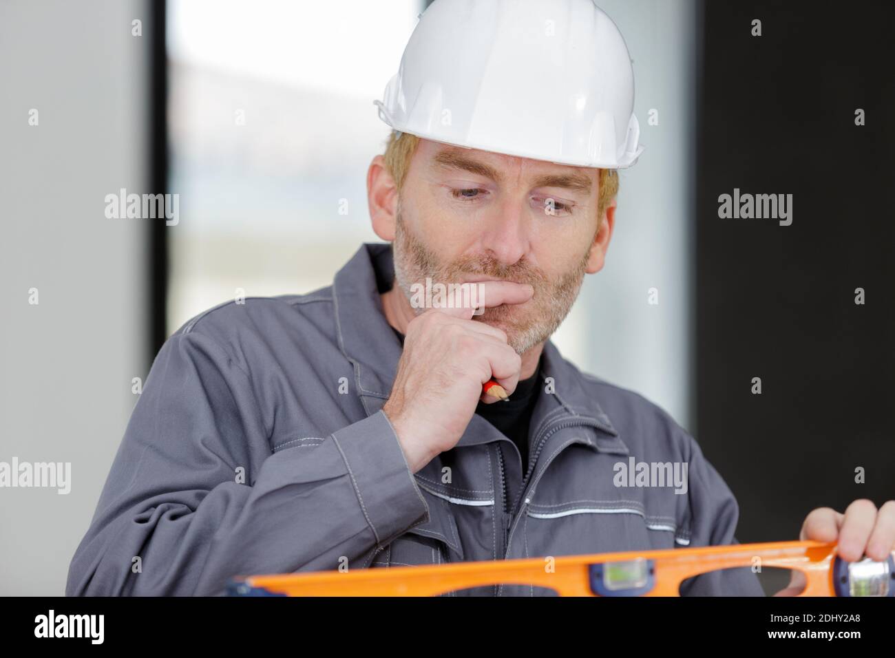 builder using a level near the wall Stock Photo - Alamy