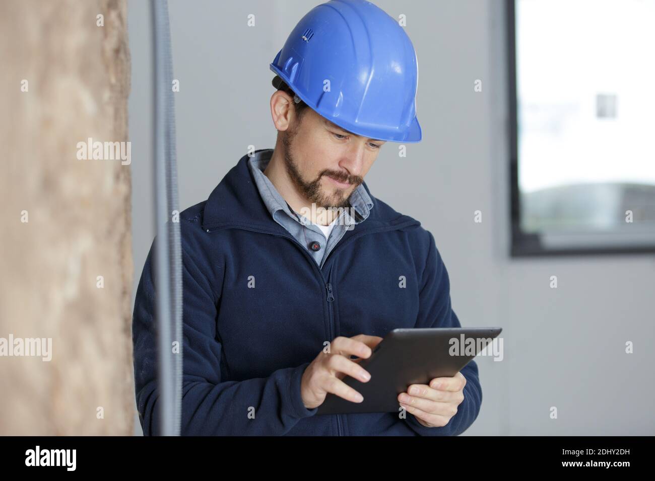 workman using tablet pc in renovation property Stock Photo - Alamy