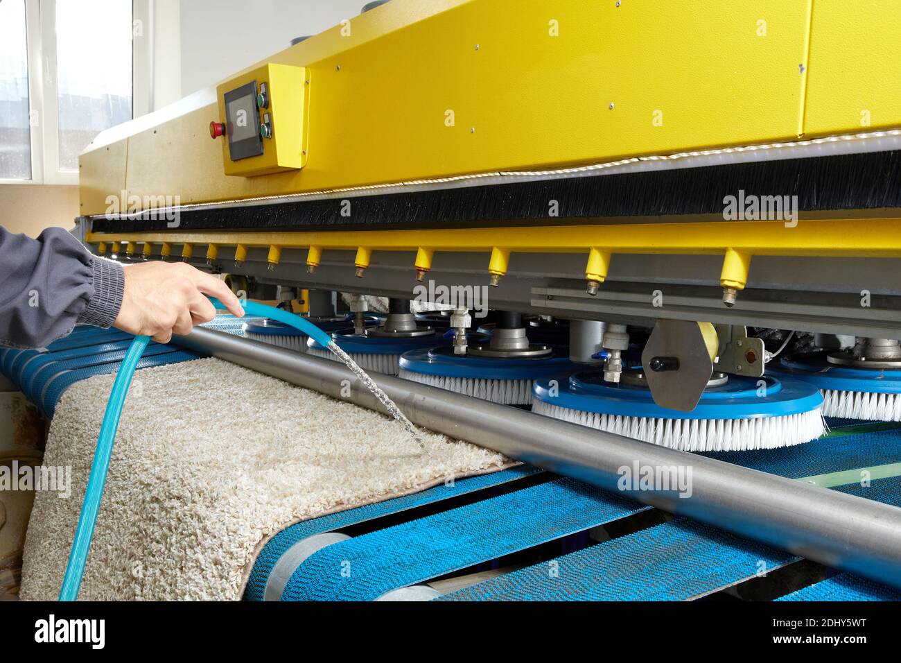 Male worker cleaning carpet on automatic washing machine equipment and ...
