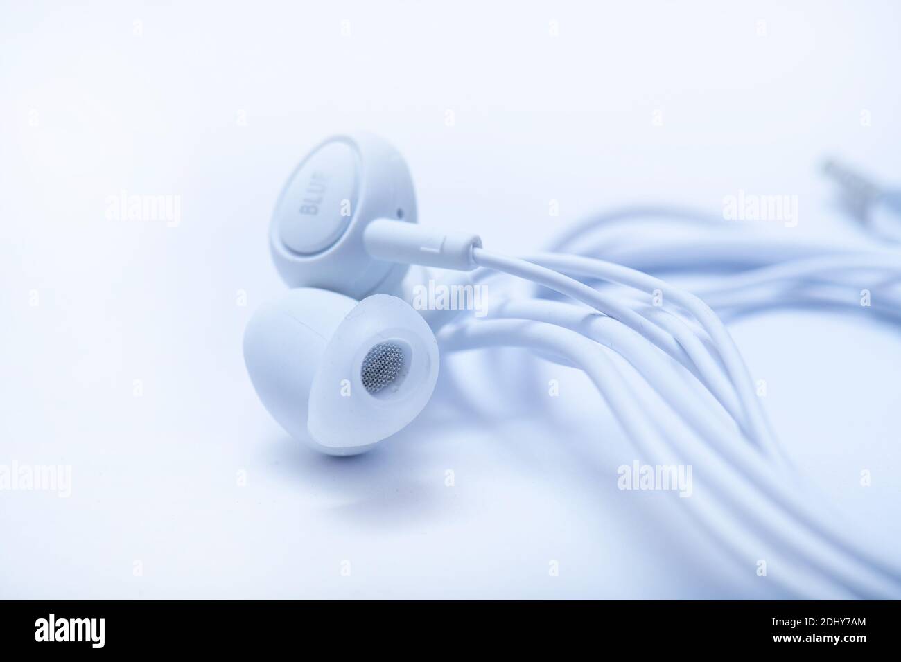 White wired earphones on white background Stock Photo - Alamy