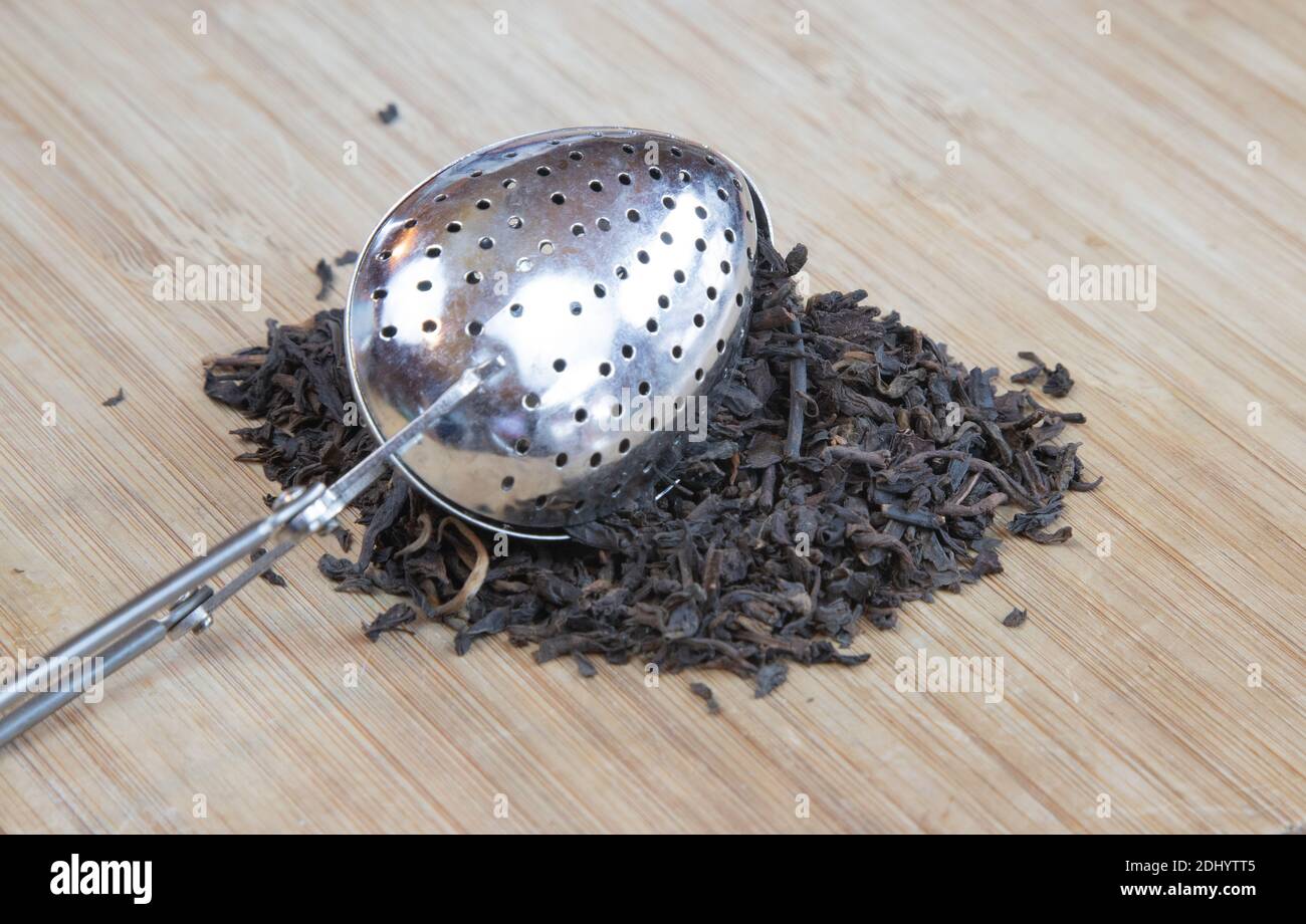 A pile of loose, dried tea leaves with a diffuser spoon Stock Photo - Alamy