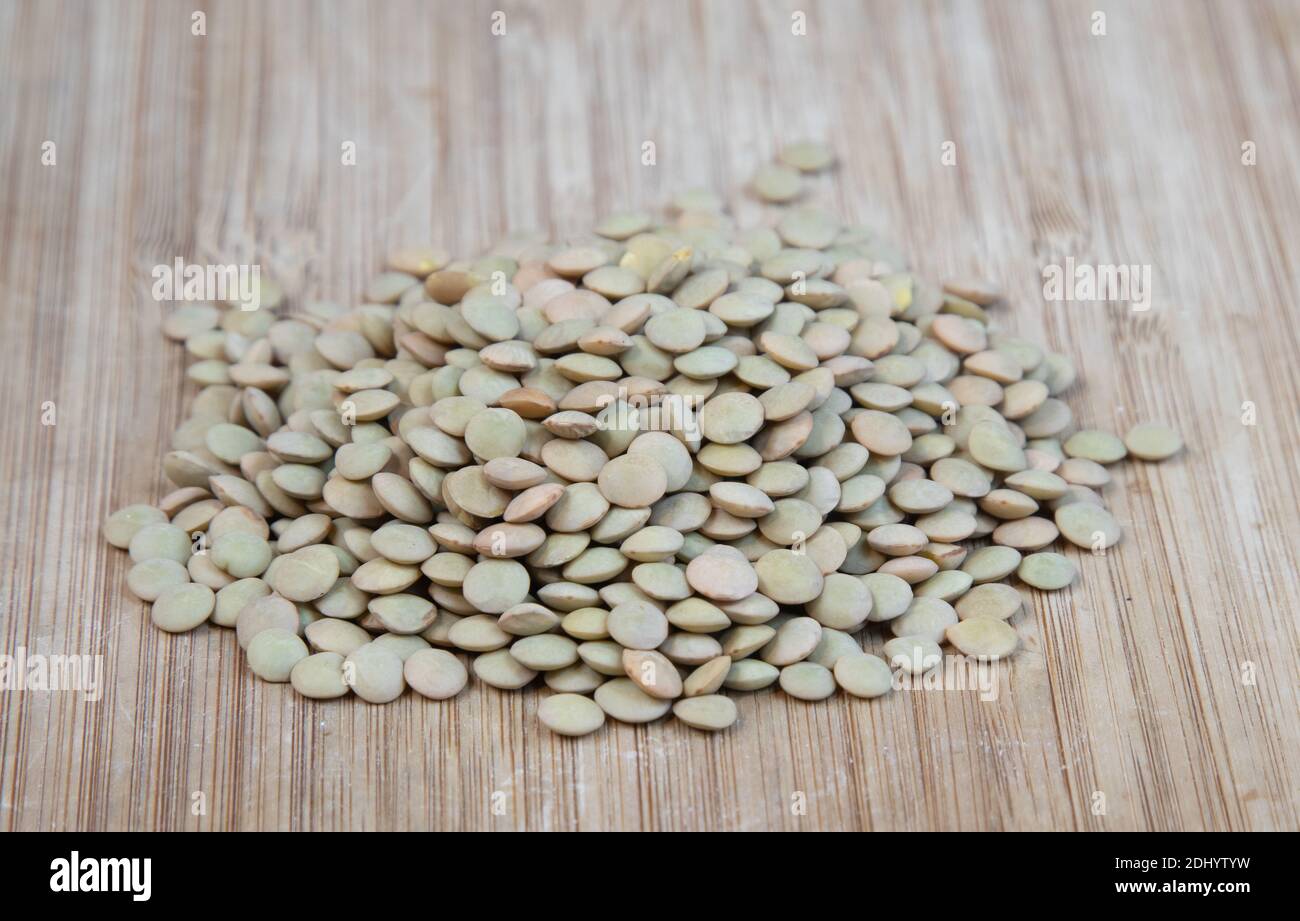 A pile of brown lentils on a wood surface Stock Photo - Alamy