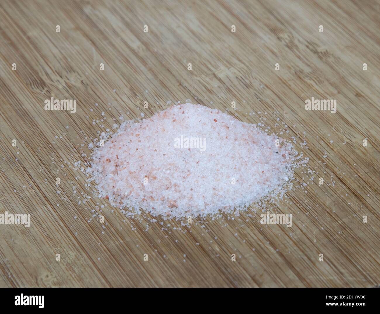 A pile of coarse himalayan pink salt on a wooden surface Stock Photo ...
