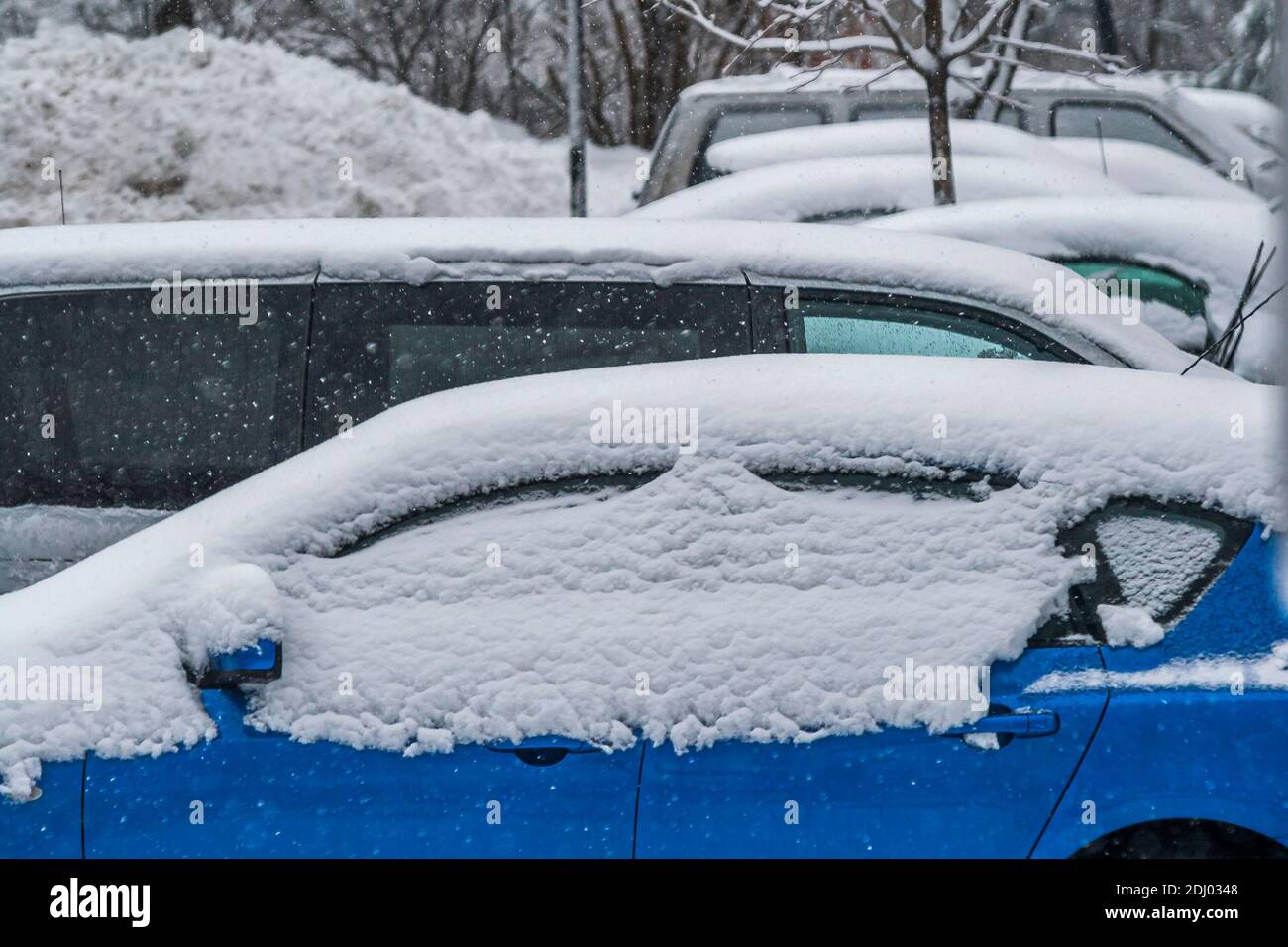 Vehicles in a residential parking lot stuck and covered by snow during ...