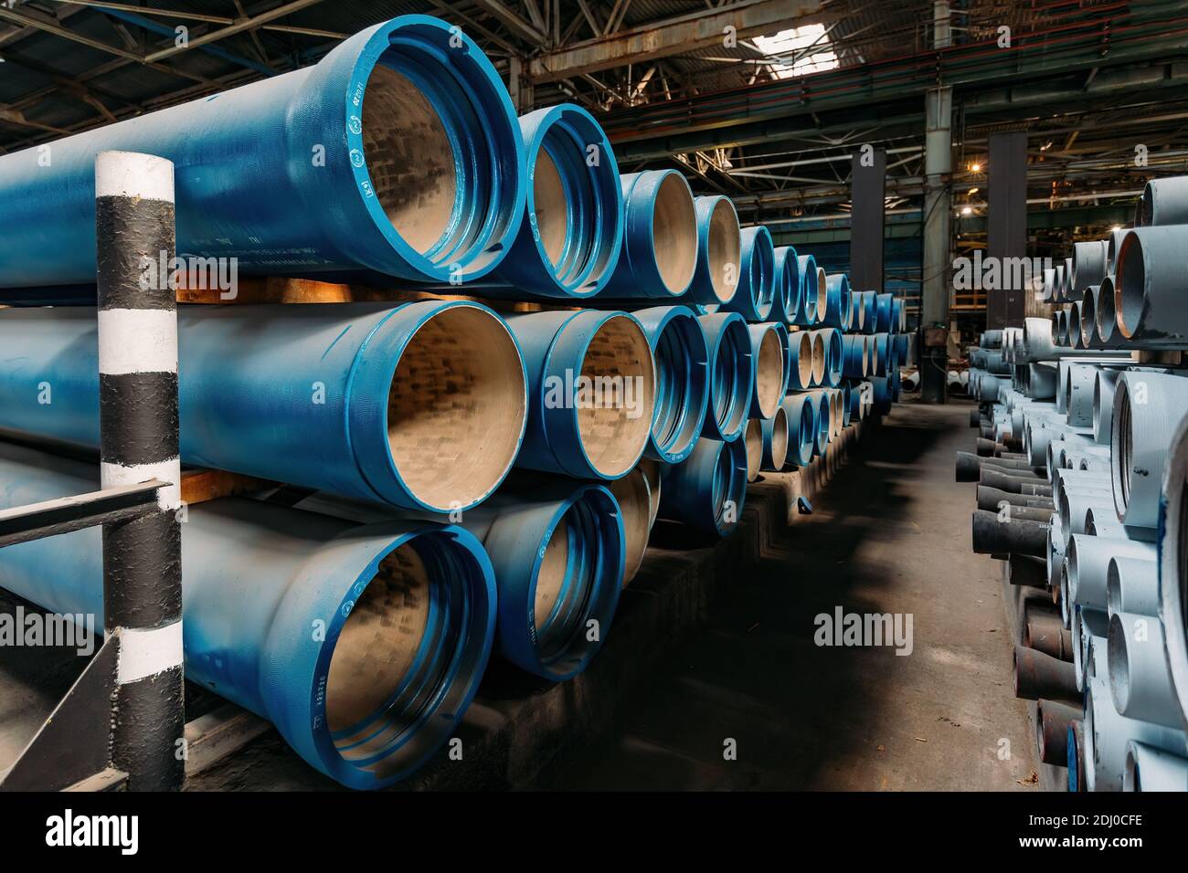 New cast iron pipes for pipeline construction in warehouse Stock Photo ...