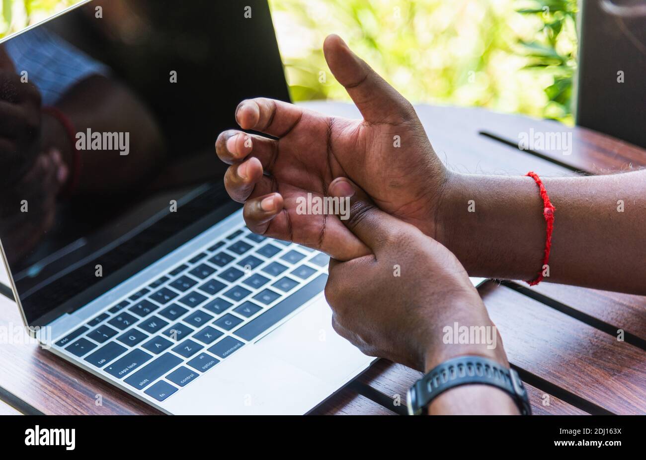 Closeup hands the Asian black man holding his wrist pain from using ...