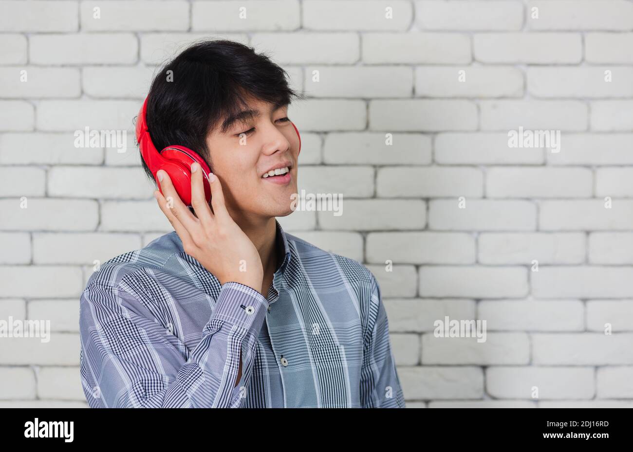 Portrait of Asian handsome young man he smile listening to music in ...